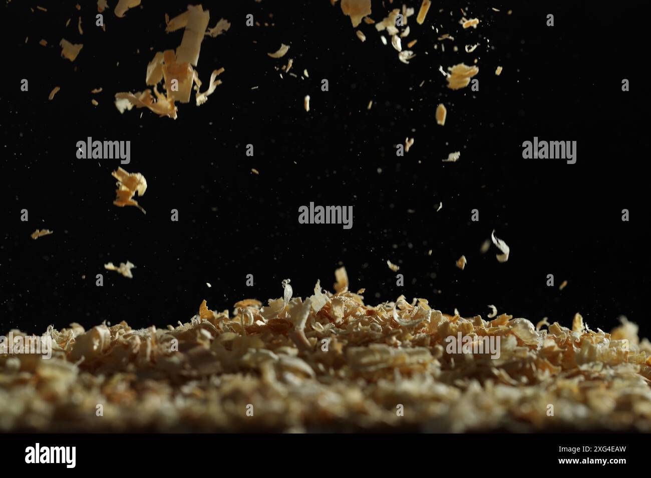 Dry natural sawdust falling on black background Stock Photo - Alamy