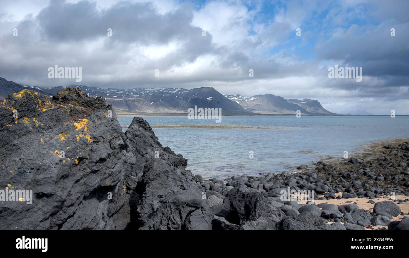 Panoramic coastline with black lava rocks and bright sand at Budir Bay ...