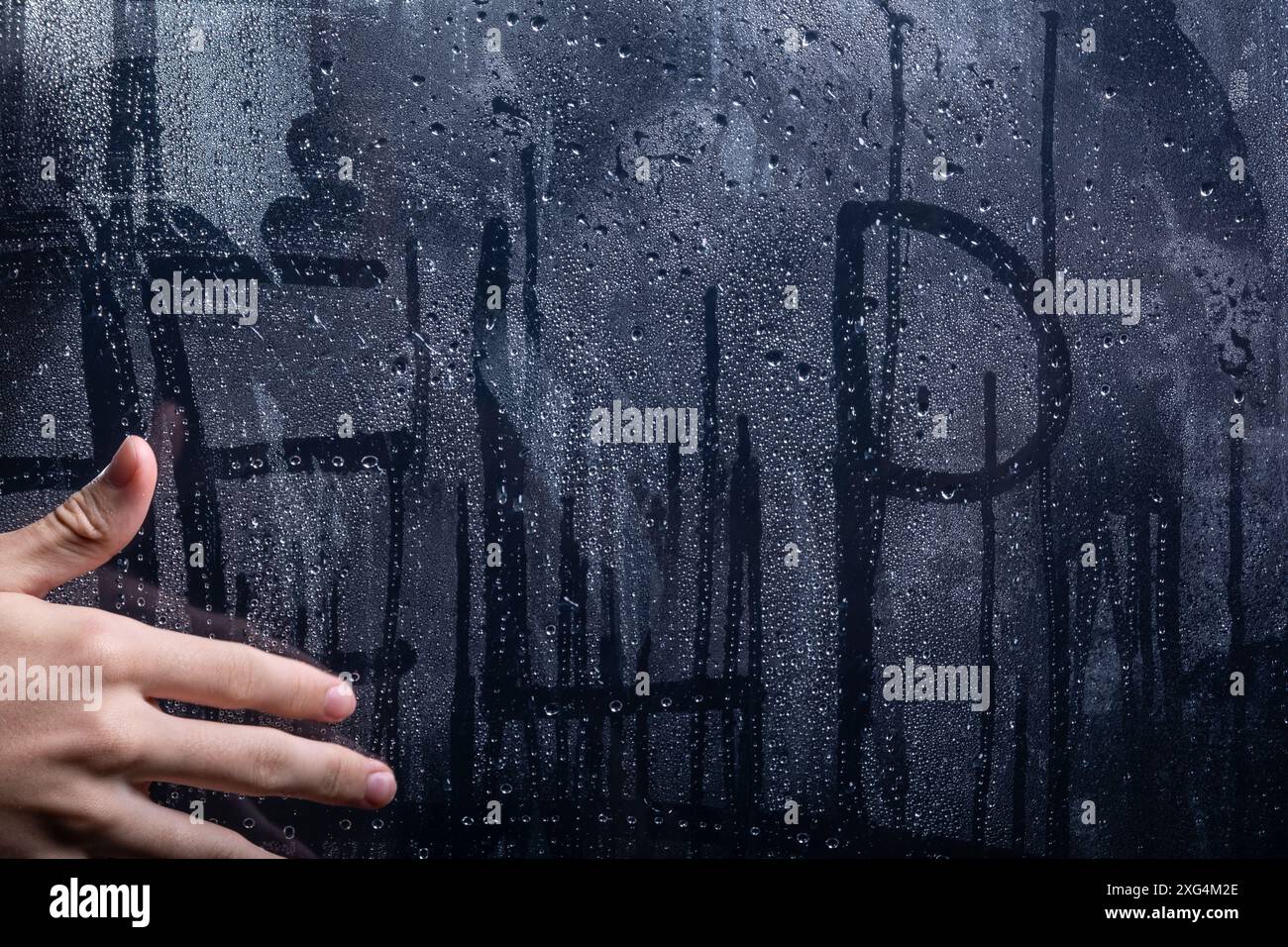 The word help written on a transparent glass wet with water drops ...