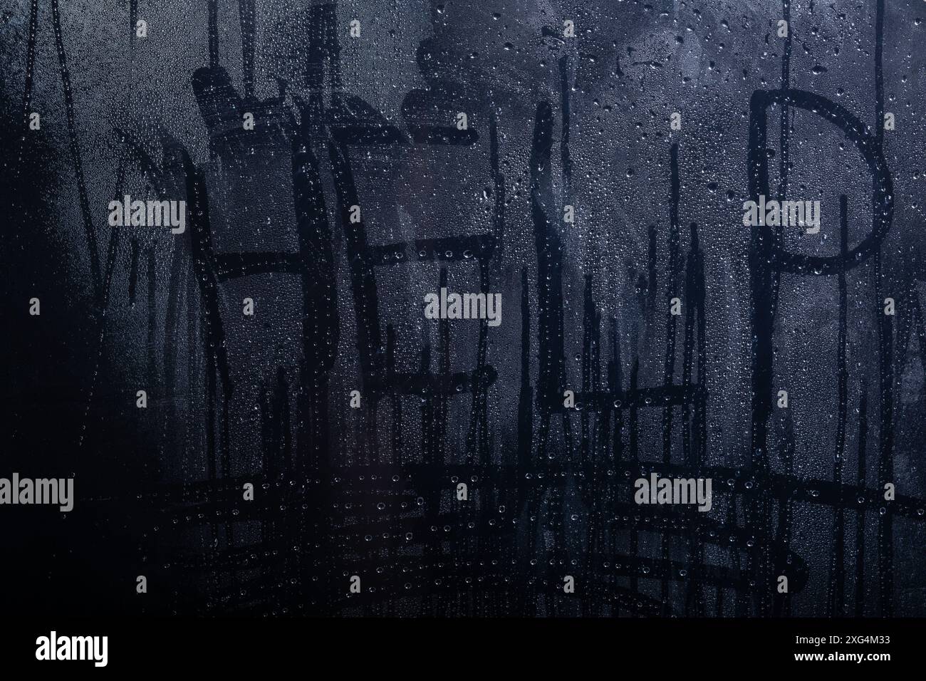 The word help written on a transparent glass wet with water drops ...