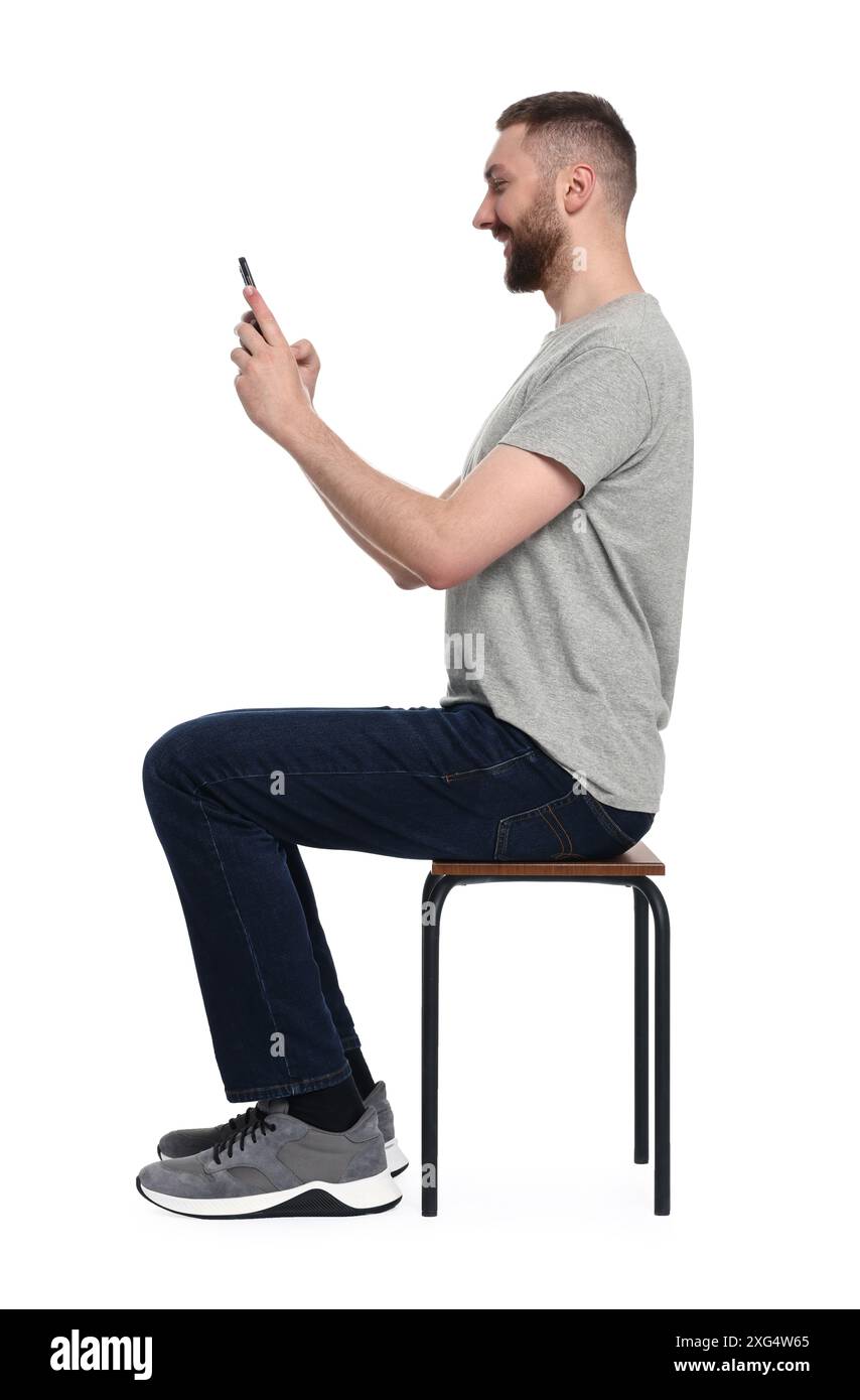 Man with good posture sitting on chair and using smartphone against ...