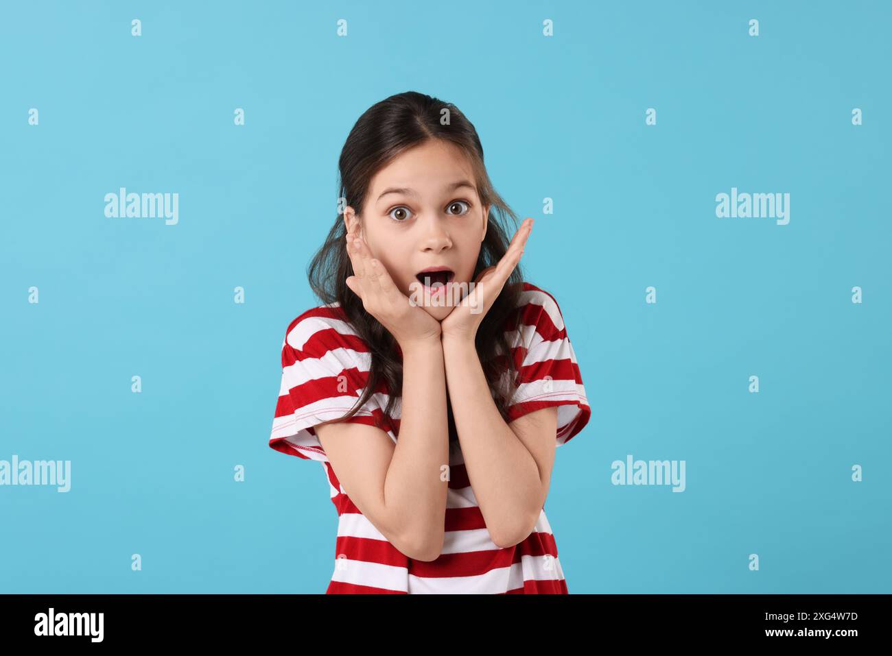 Portrait of emotional girl on light blue background Stock Photo - Alamy