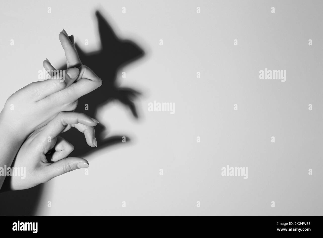 Shadow puppet. Woman making hand gesture like rabbit on light ...