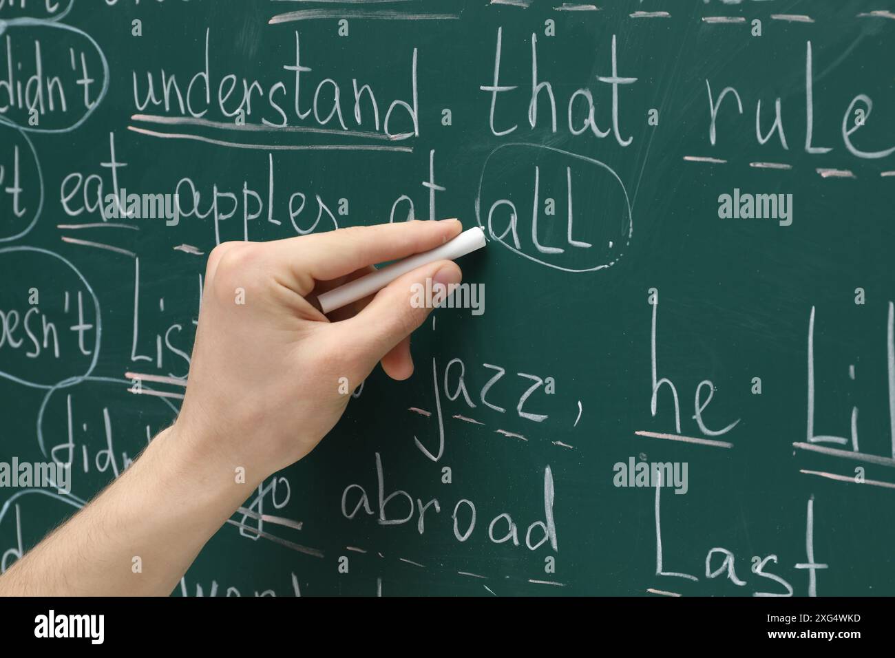 English teacher writing with chalk on green chalkboard, closeup Stock ...