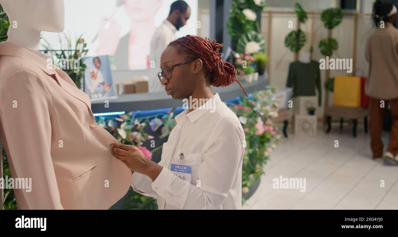 African american employee working in SH clothing shop arranging nice ...