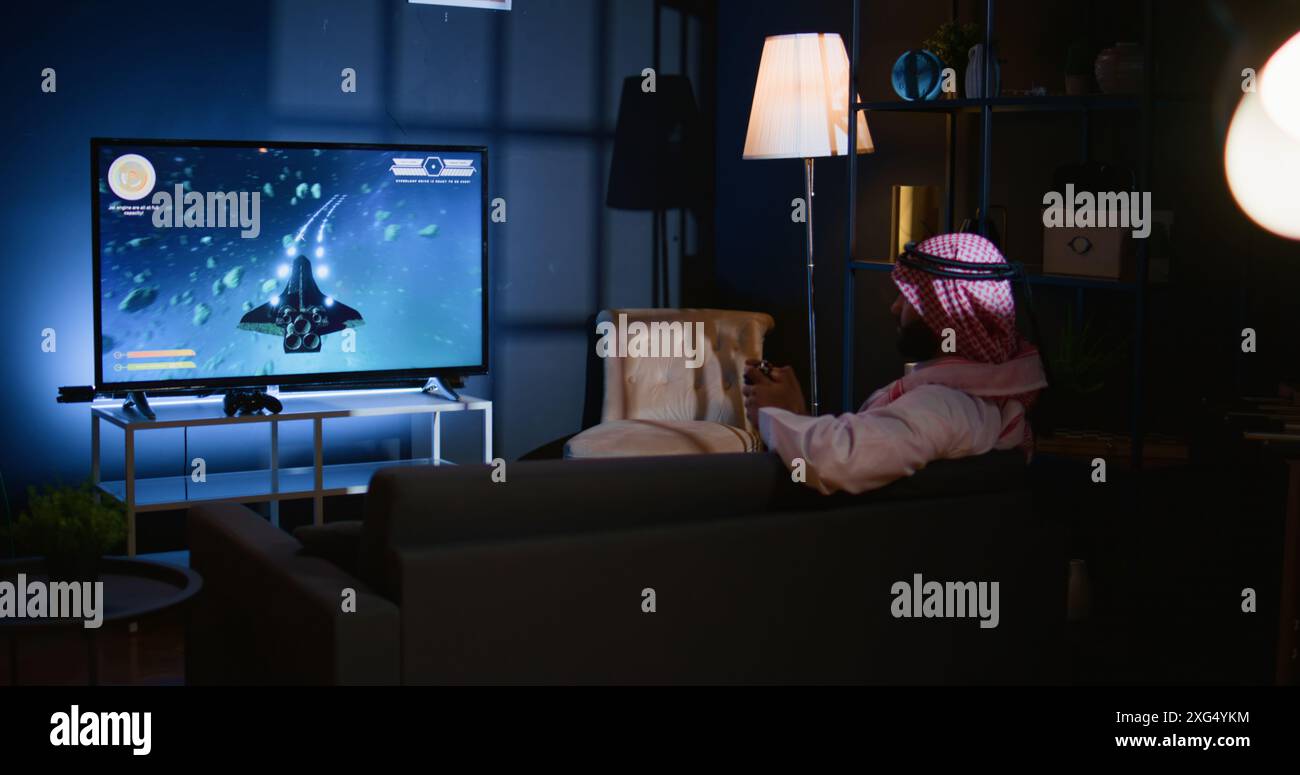 Arab gamer playing classic arcade space shooter videogame, shooting ...