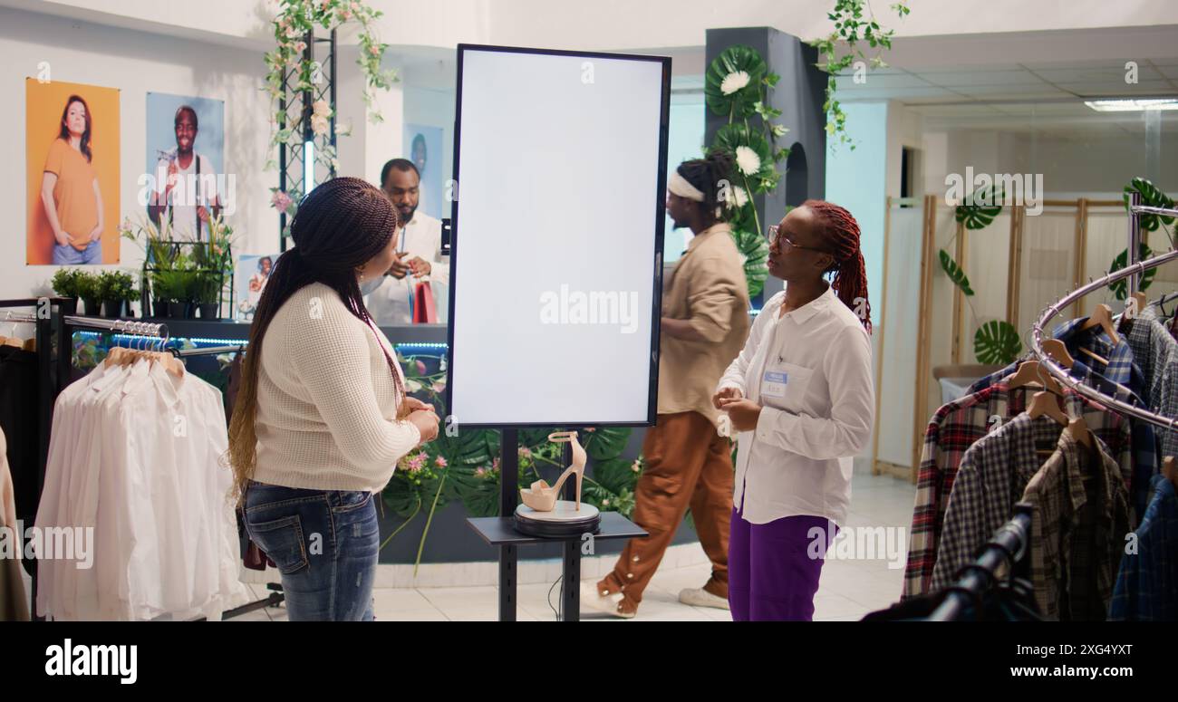 Employee in shopping center fashion boutique using high tech screen to ...
