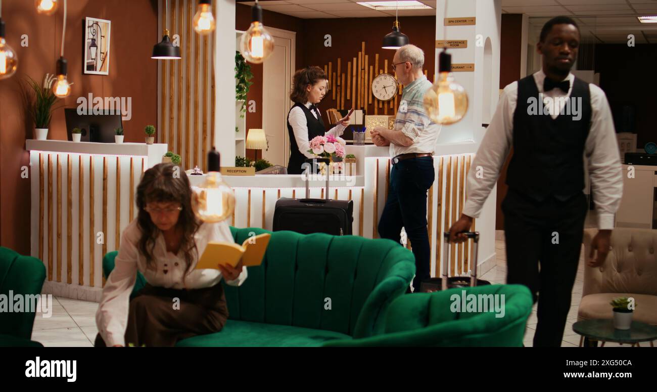 Hotel staff checks id on passport of elderly client arriving at ...