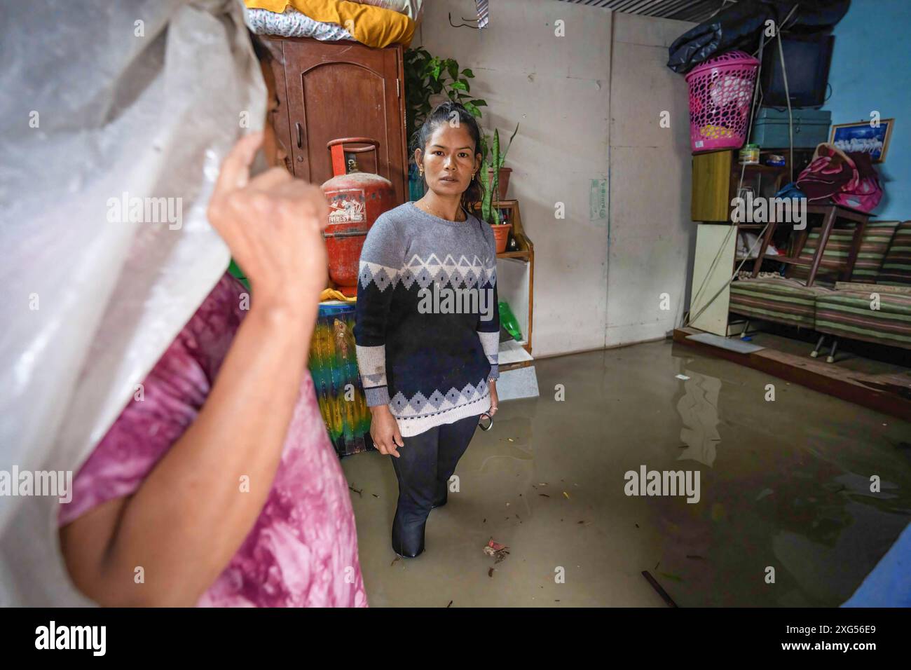 Nepalese woman stands inside her flooded house as a river overflows ...