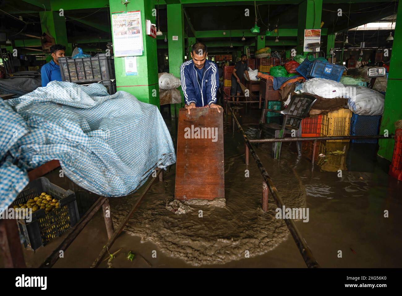 A man seen at a flooded vegetable market as a river overflows after ...