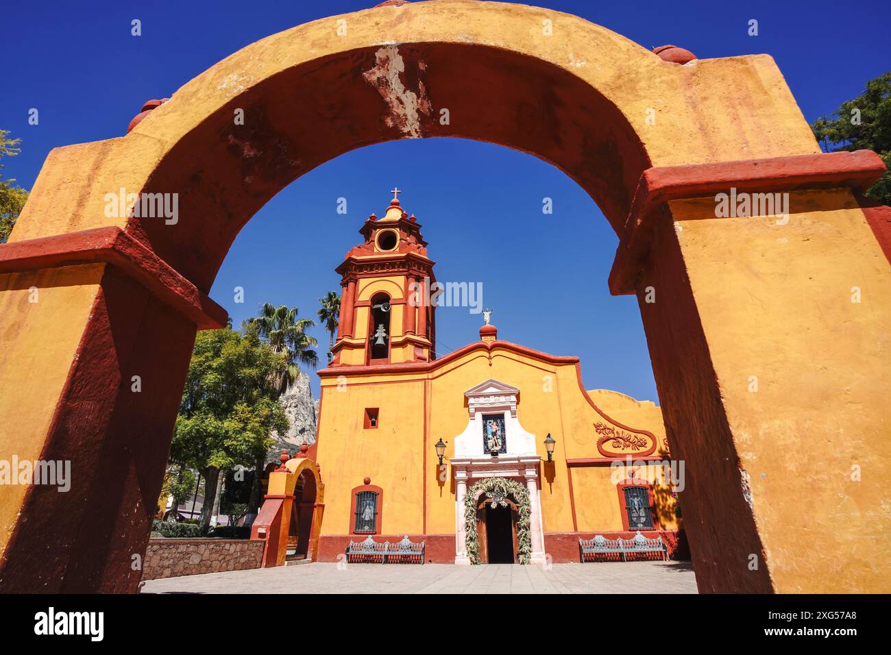The Parroquia San Sebastian church with the massive Pena de Bernal rock ...