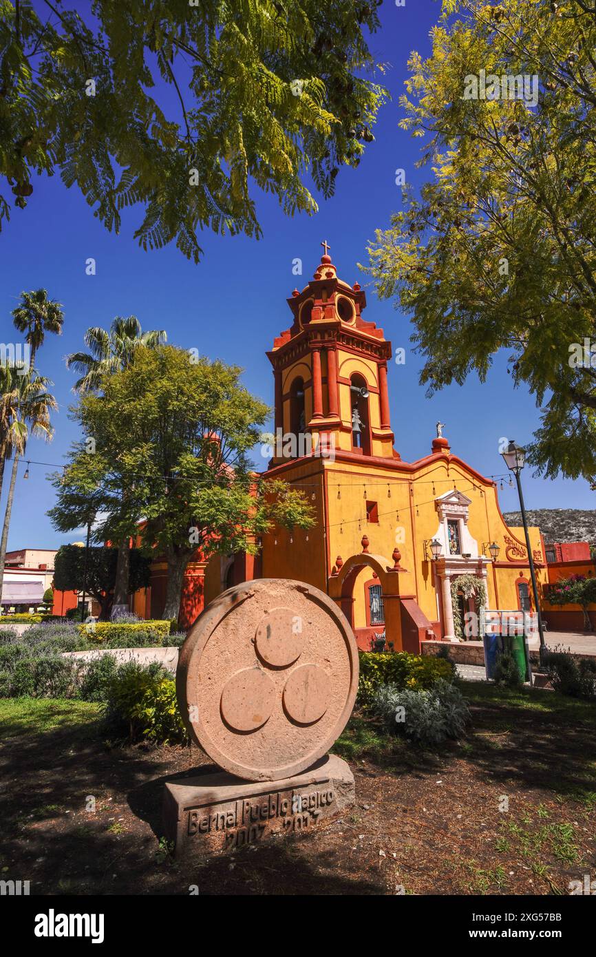 The Parroquia San Sebastian church with the massive Pena de Bernal rock ...
