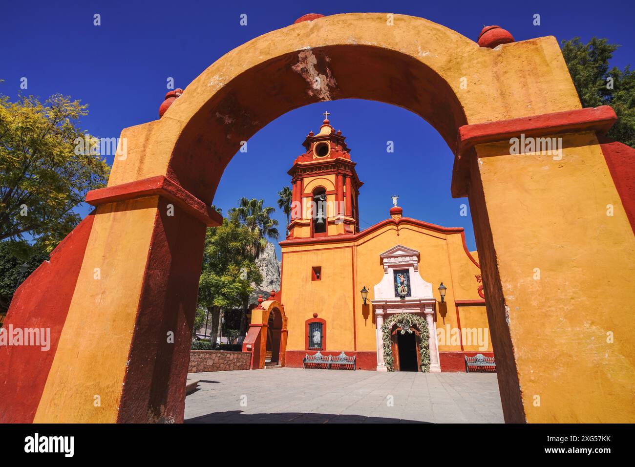 The Parroquia San Sebastian church with the massive Pena de Bernal rock ...