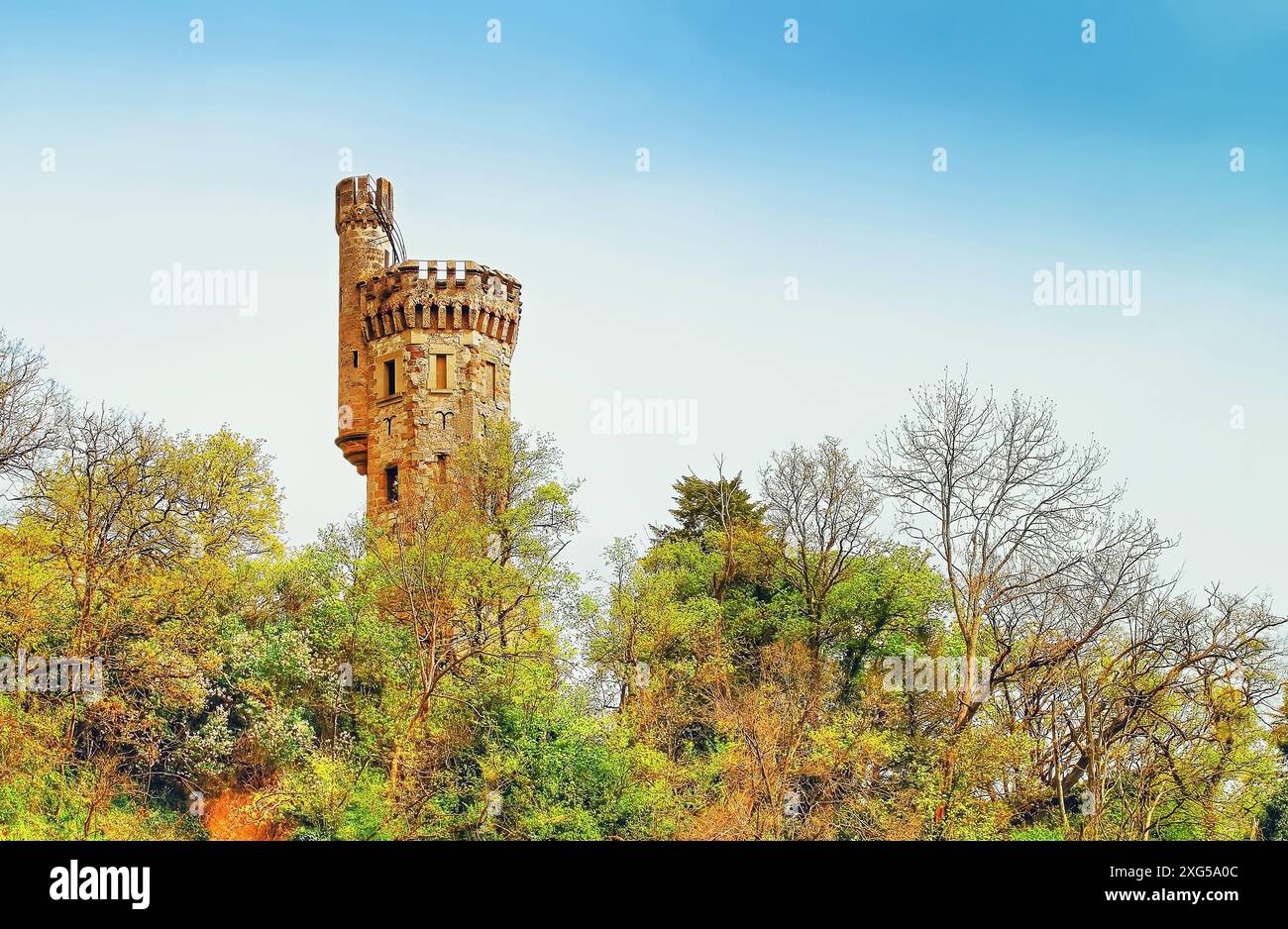 Old abandoned ancient watch tower on an overgrown hillside against the sky. HDR rendered image ...