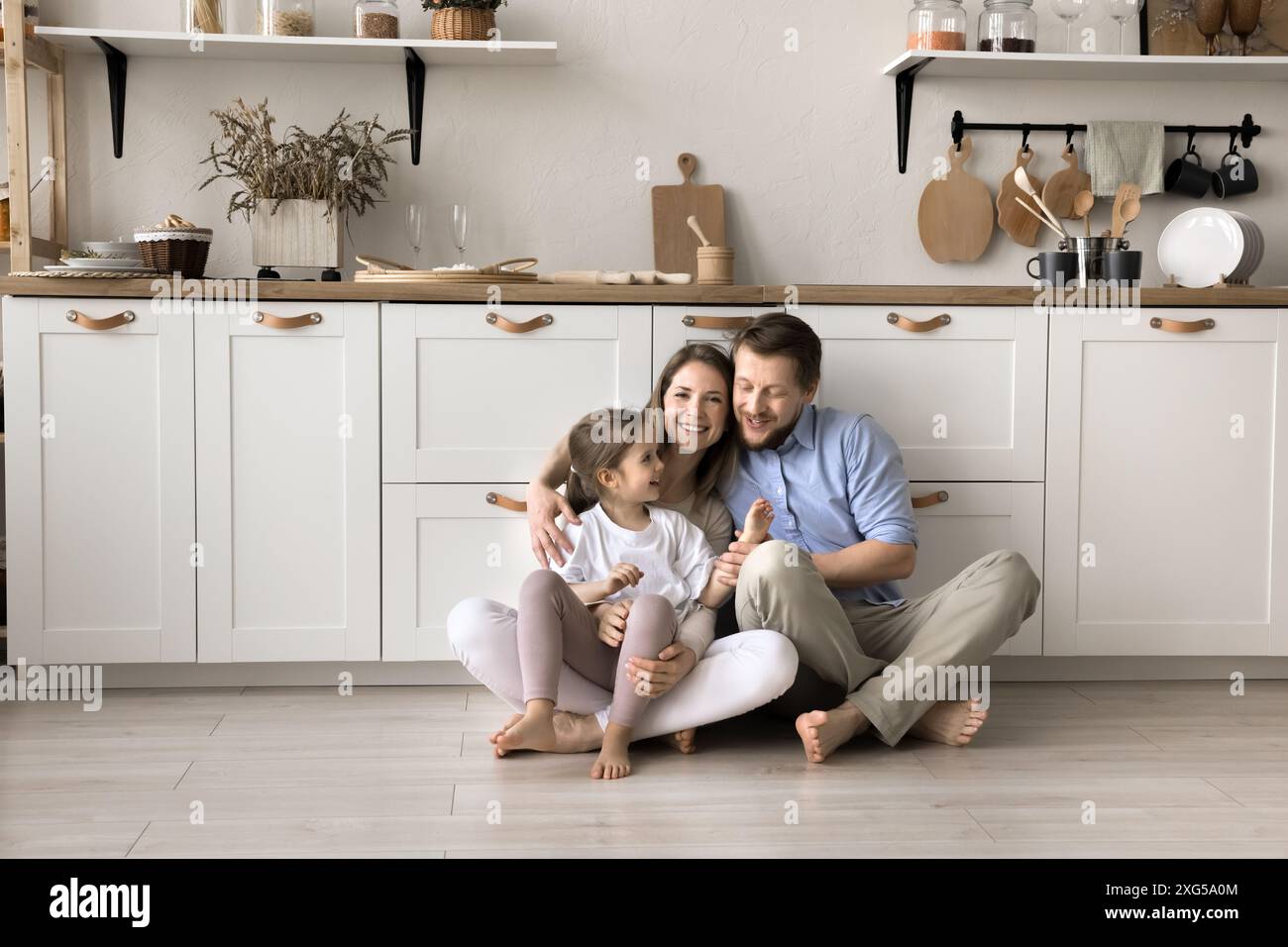 Family with daughter sit on floor in modern home kitchen Stock Photo ...