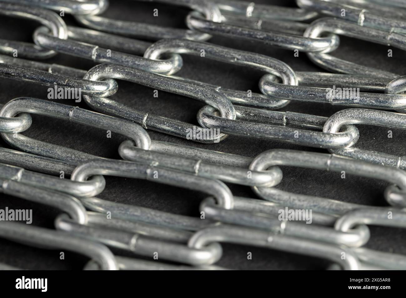 silver steel chain on a black background, steel chain links connected ...
