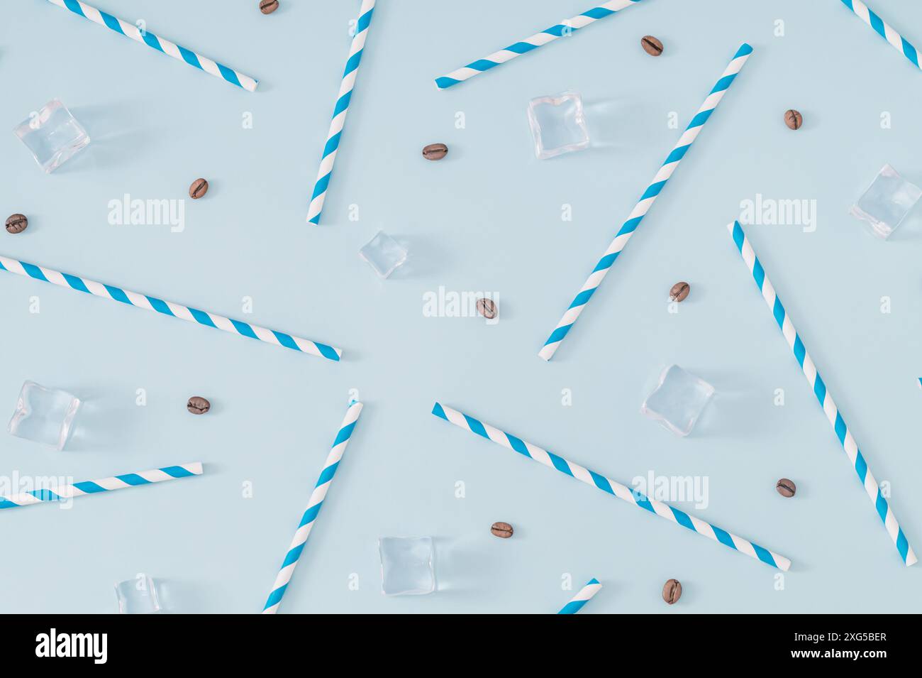 Coffee beans, ice cubes and white and blue paper drinking straws ...