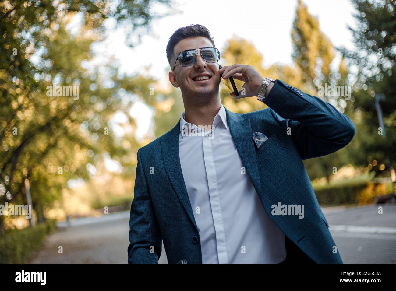 A professional man in a formal suit conversing on a cell phone in an ...