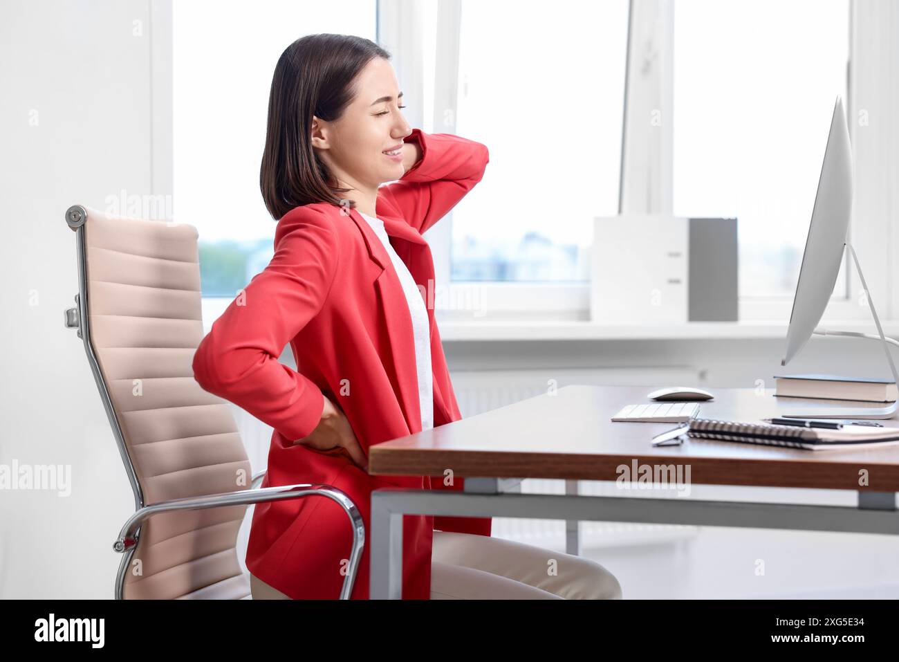 Woman suffering from neck pain in office. Symptom of poor posture Stock ...
