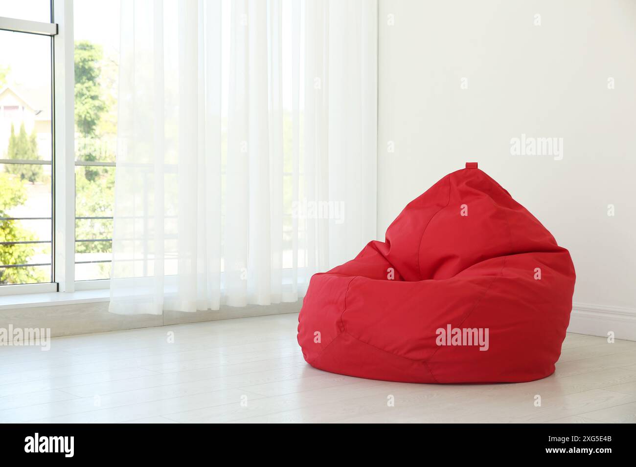 Red bean bag chair near window in room. Space for text Stock Photo - Alamy