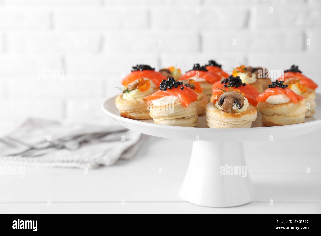 Different delicious puff pastry snacks on white wooden table, space for ...