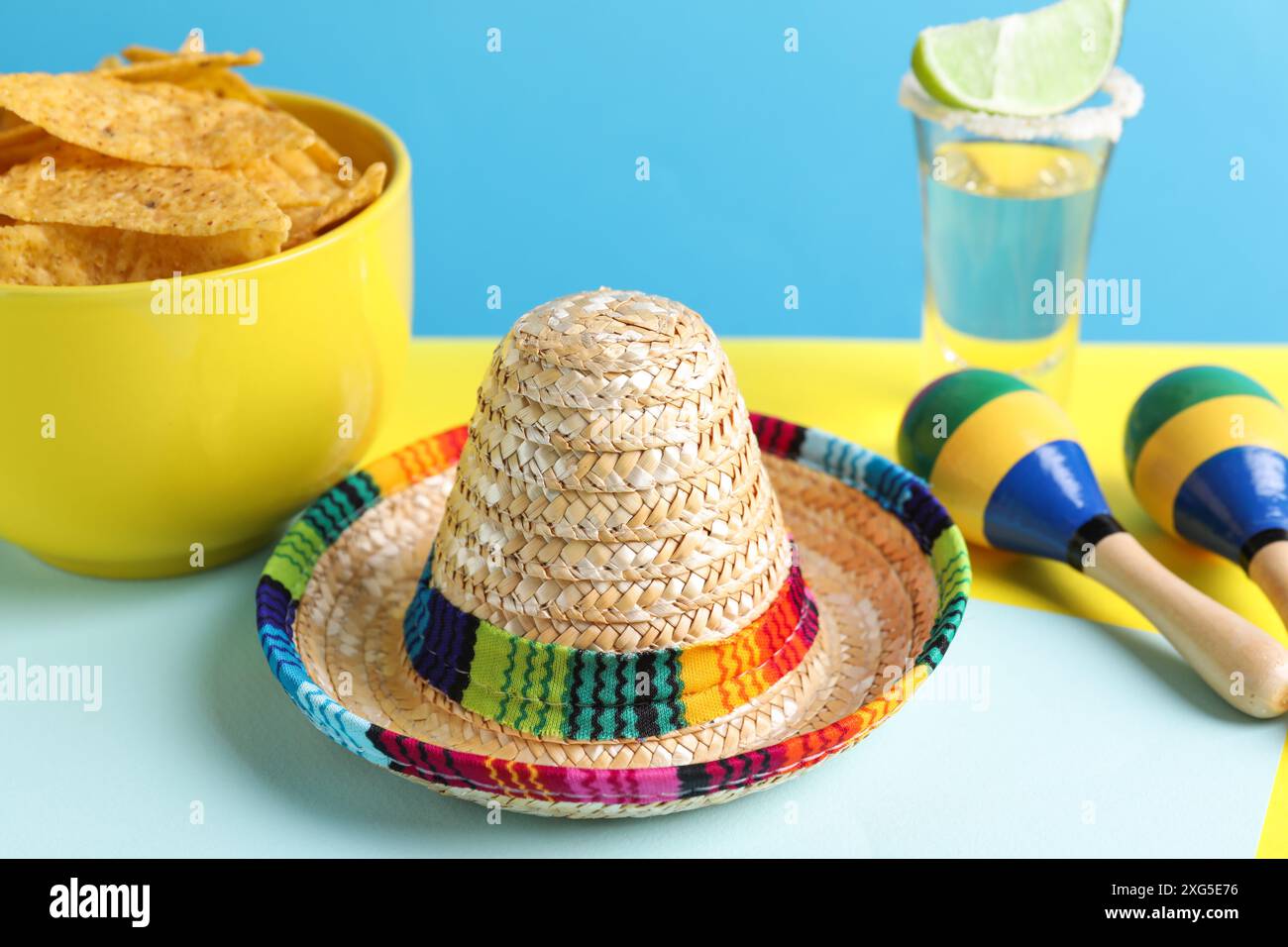 Mexican sombrero hat, nachos chips, maracas and tequila on color ...