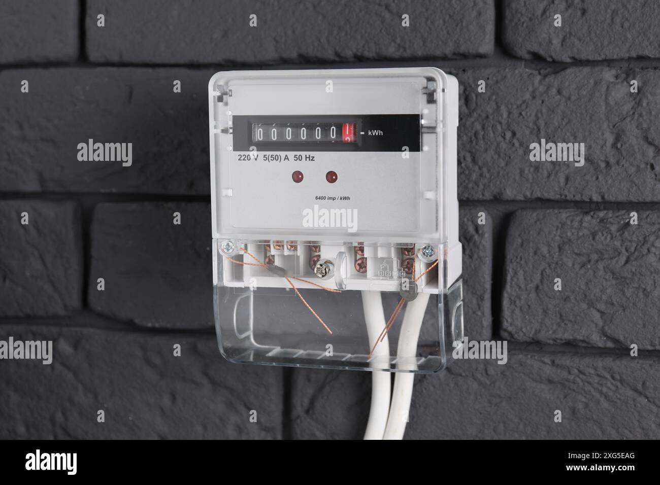 Electric meter on grey brick wall. Energy measuring device Stock Photo ...