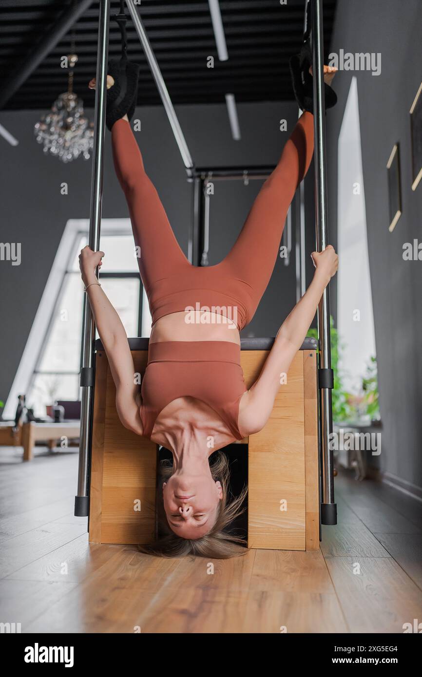 Woman doing exercise upside down, inverted position on Balanced Body ...