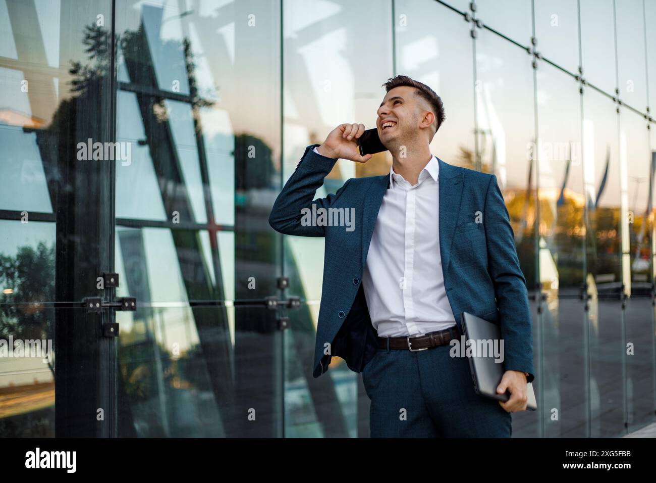 A businessman in a blue suit and white shirt stands in front of a ...