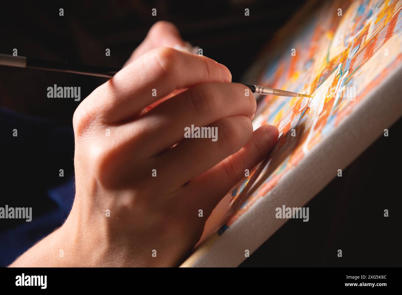 Close-up of a female artist's hand painting with watercolors color on ...
