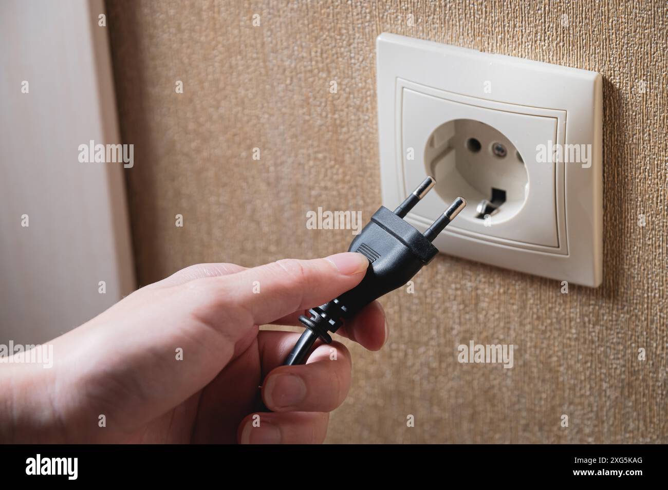 A woman's hand inserts an electric plug into a socket, close-up Stock ...