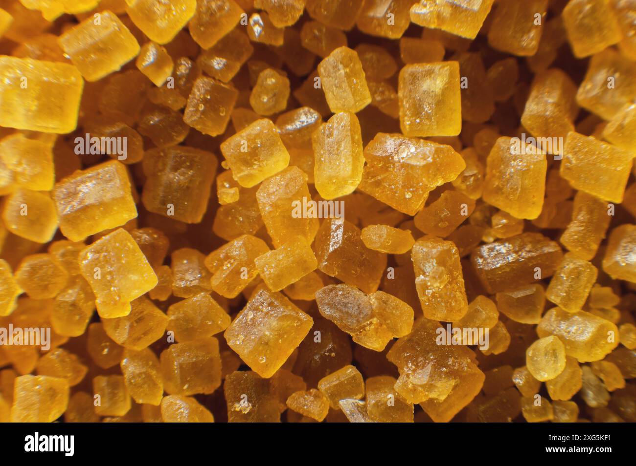 Extreme macro. Sugar crystals. Close-up of brown cane sugar on a plane ...