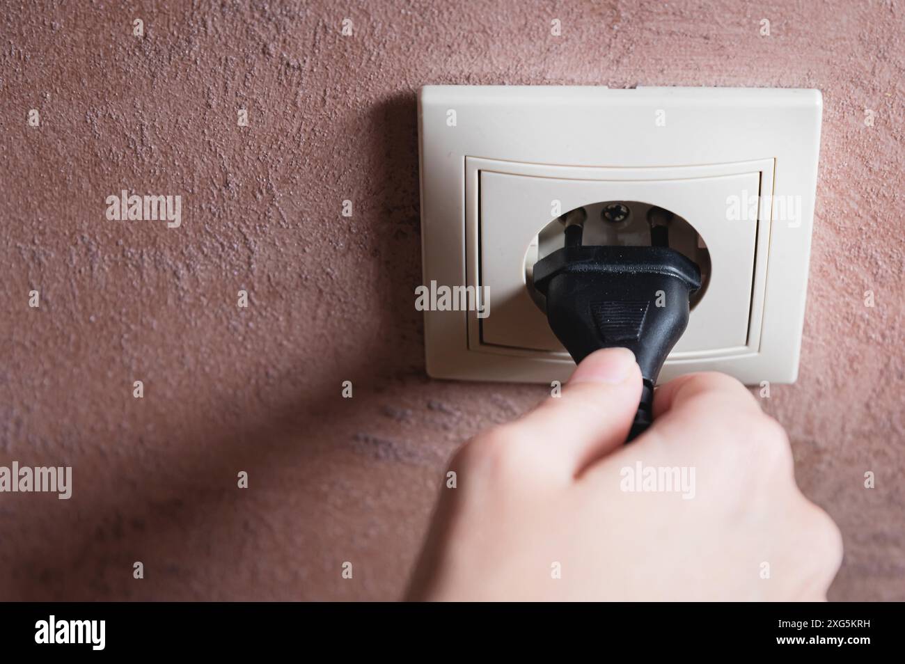 A black cord with a plug from an electrical appliance turns on or off ...