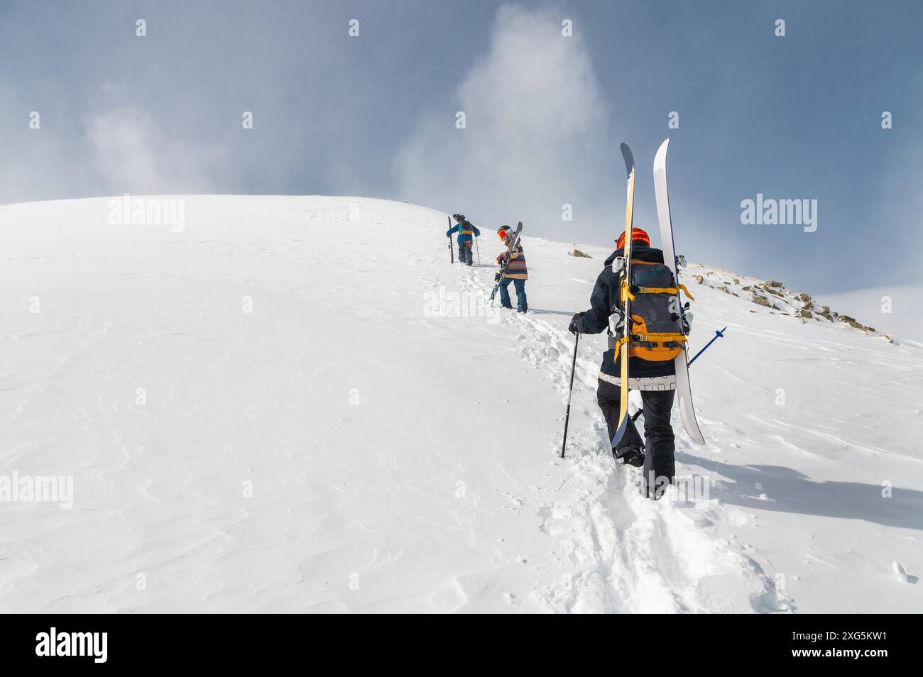 Backcountry climbers, ski climber, walking with skis and snowboard in ...