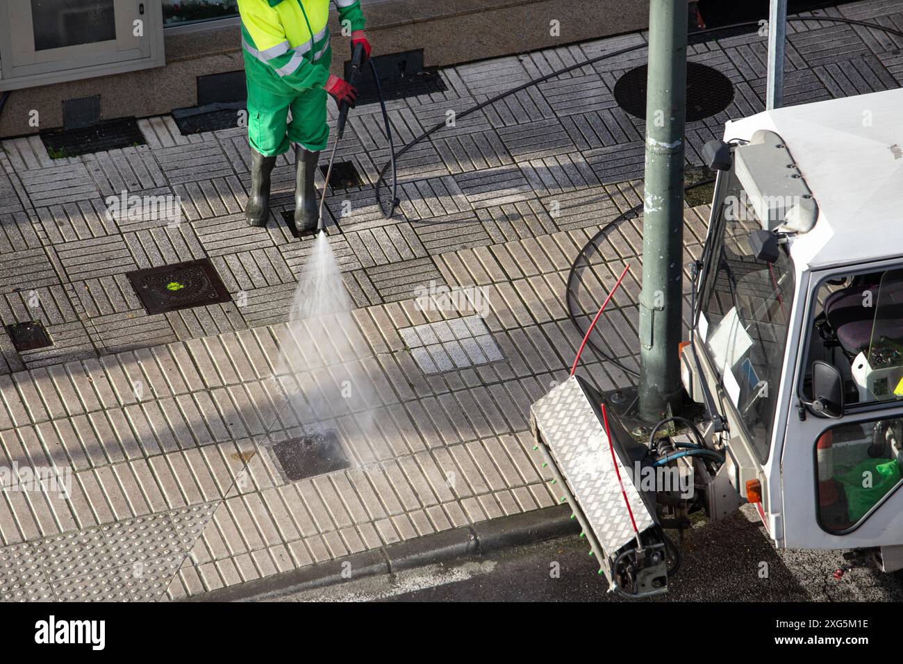 Sweeper washing a street sidewalk with high pressure water jet machine ...
