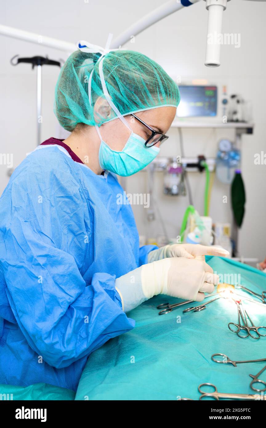 Surgery operation. Close up of surgeon hands stitching the wound after ...