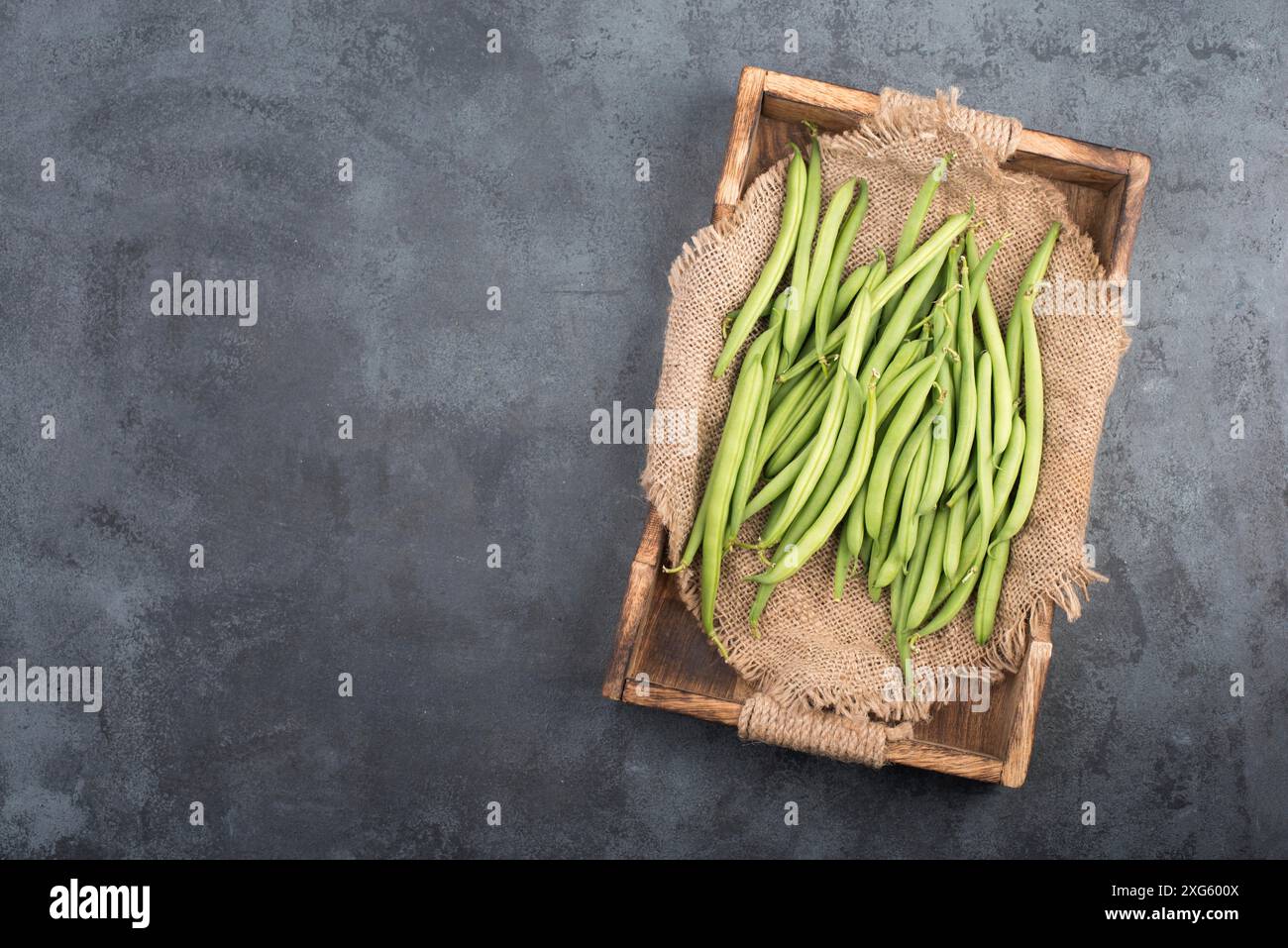 Green string beans on a textured background, empty space for text ...