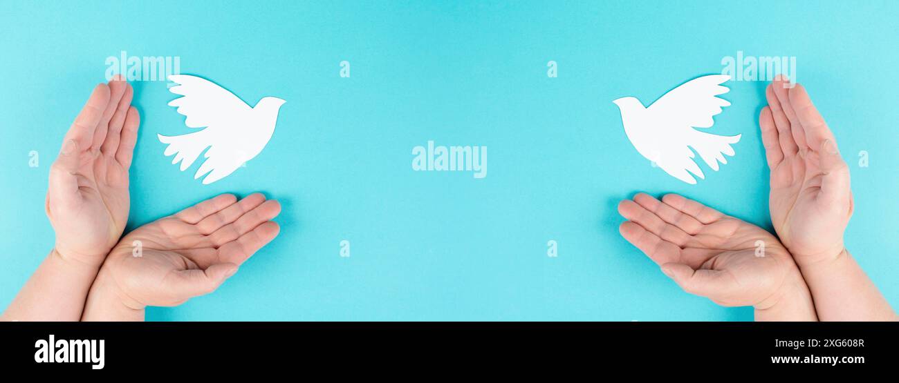 Holding a white dove in the hands, symbol of peace, paper cut out ...