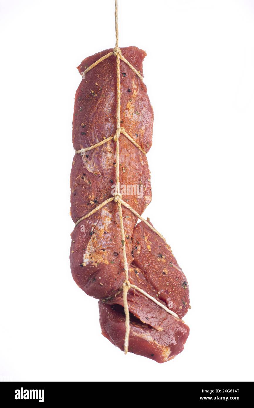 Hanging raw pork fillet on white Stock Photo - Alamy