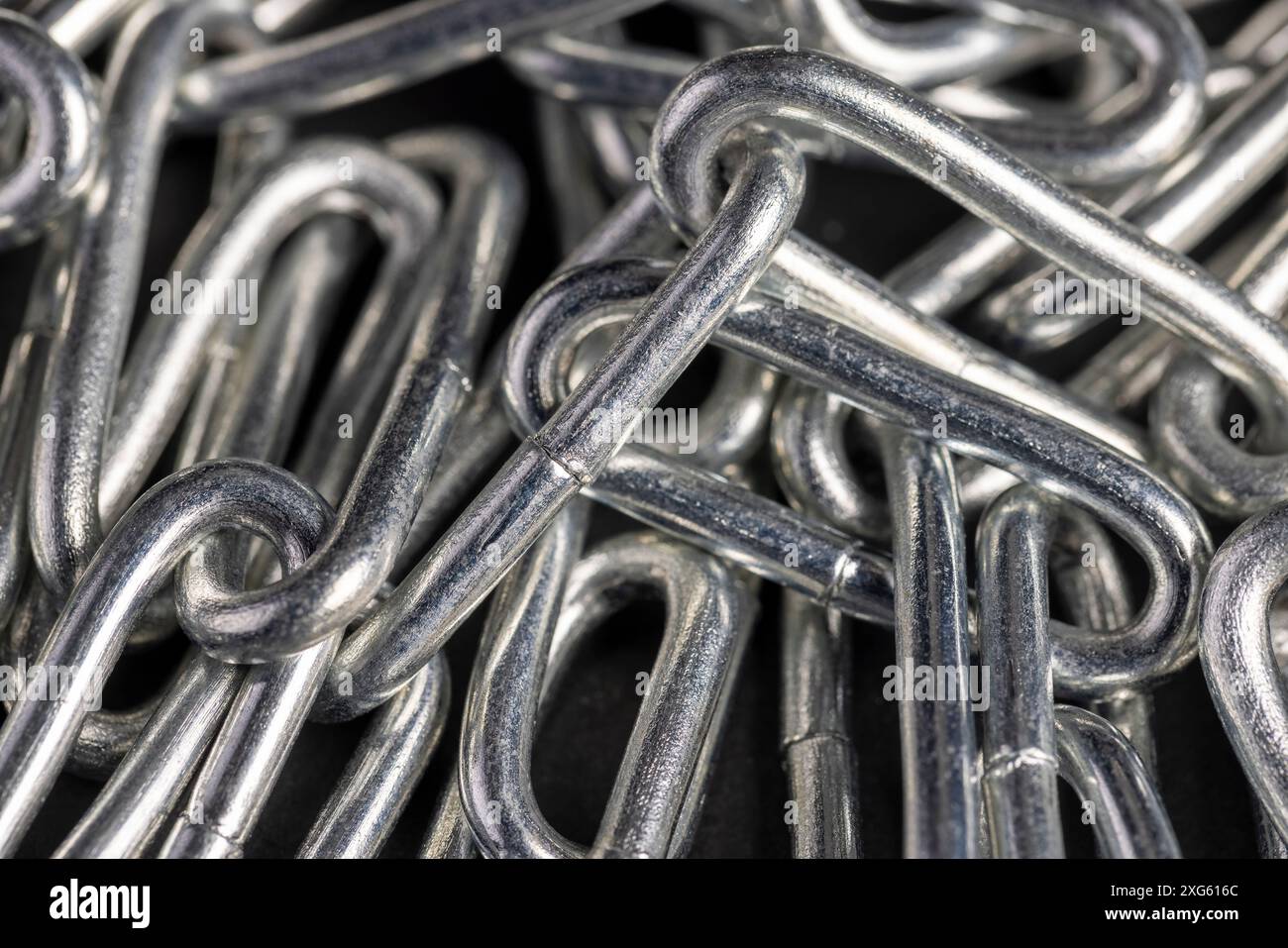 silver steel chain on a black background, steel chain links connected ...
