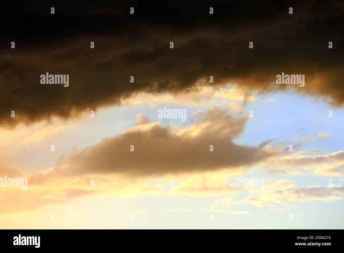Cloudy sky at sunset. The sky is visible through a gap in the clouds ...