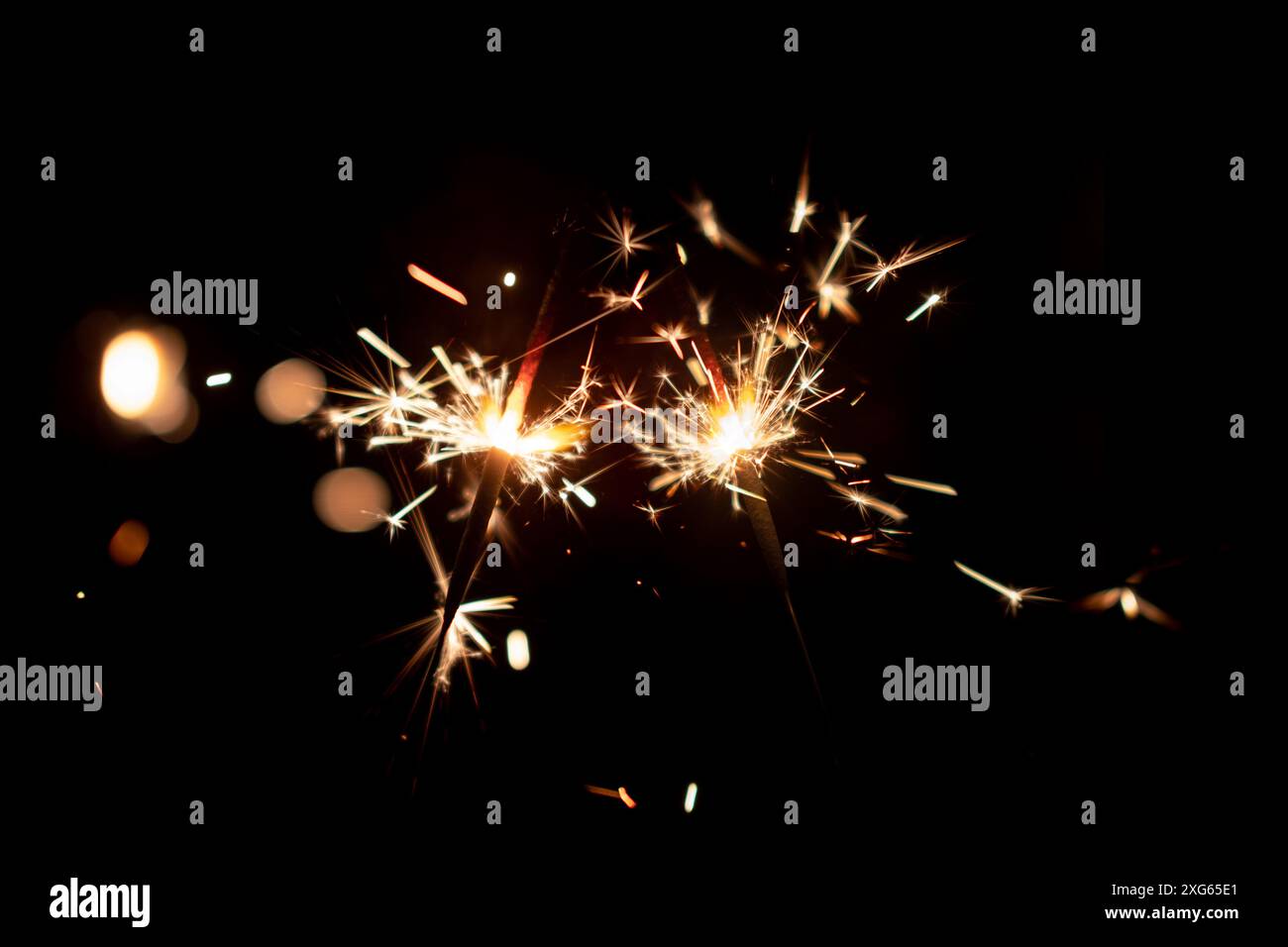 Burning two sparklers, abstract blur background Stock Photo - Alamy