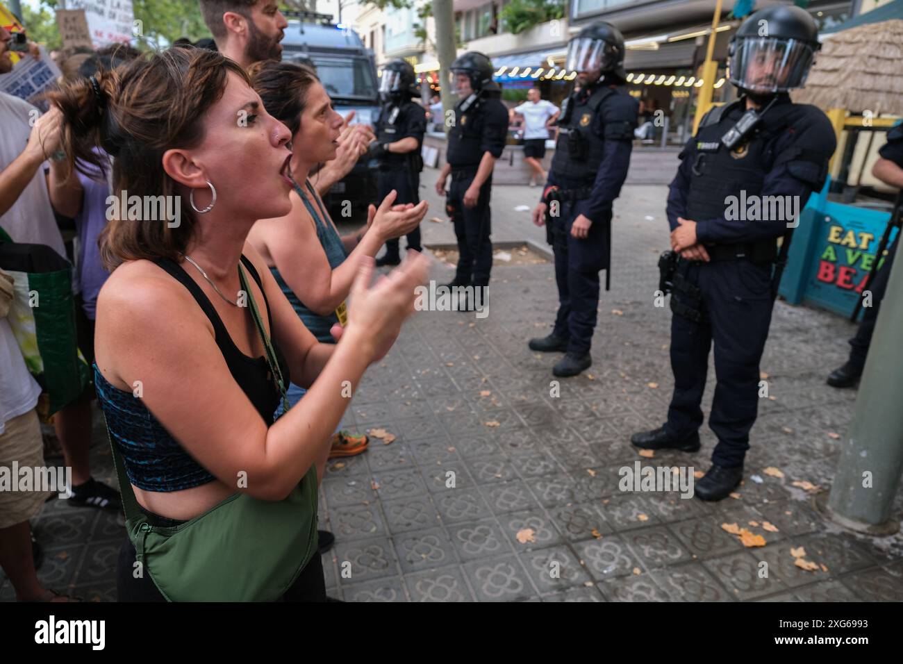 Protesters are seen shouting slogans in front of a line of regional ...
