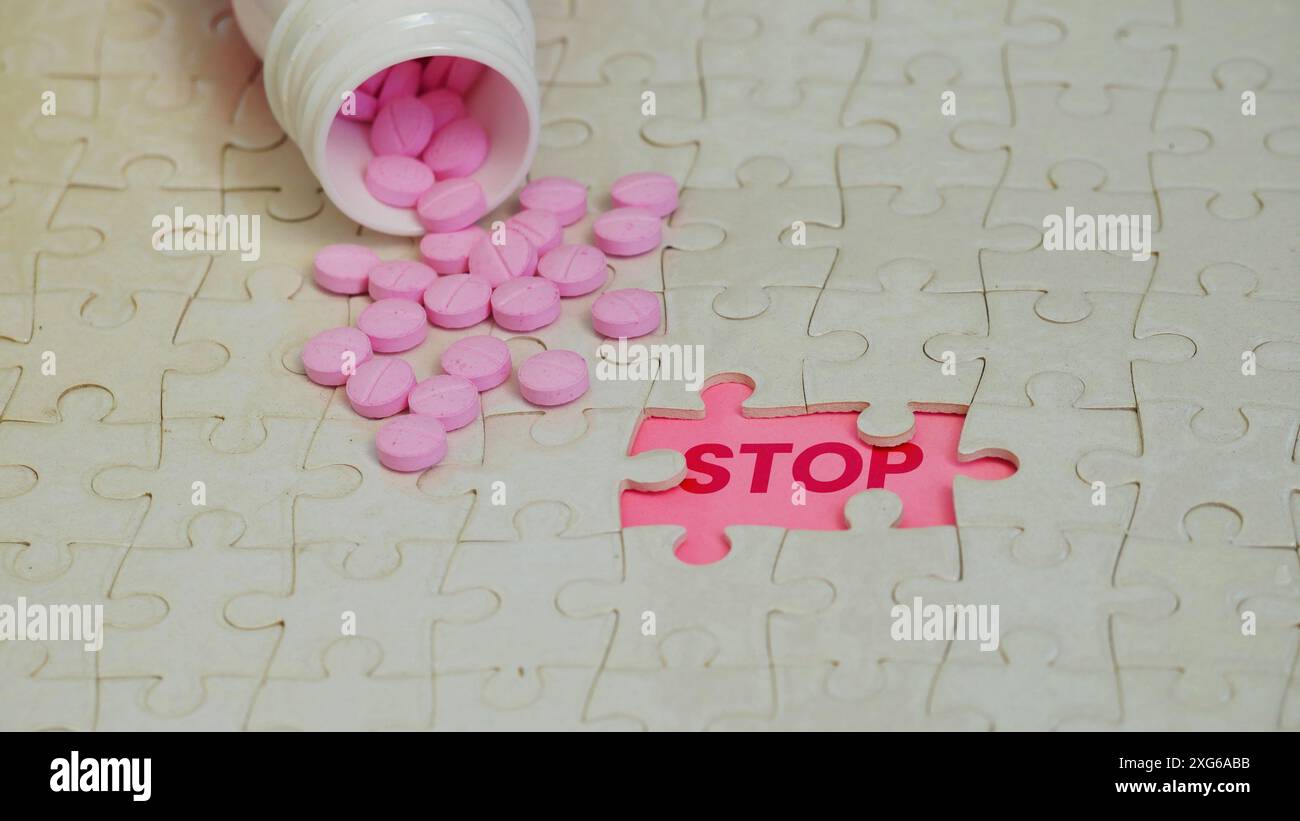 STOP text behind a jigsaw puzzle piece with drug pellets sprinkled on ...