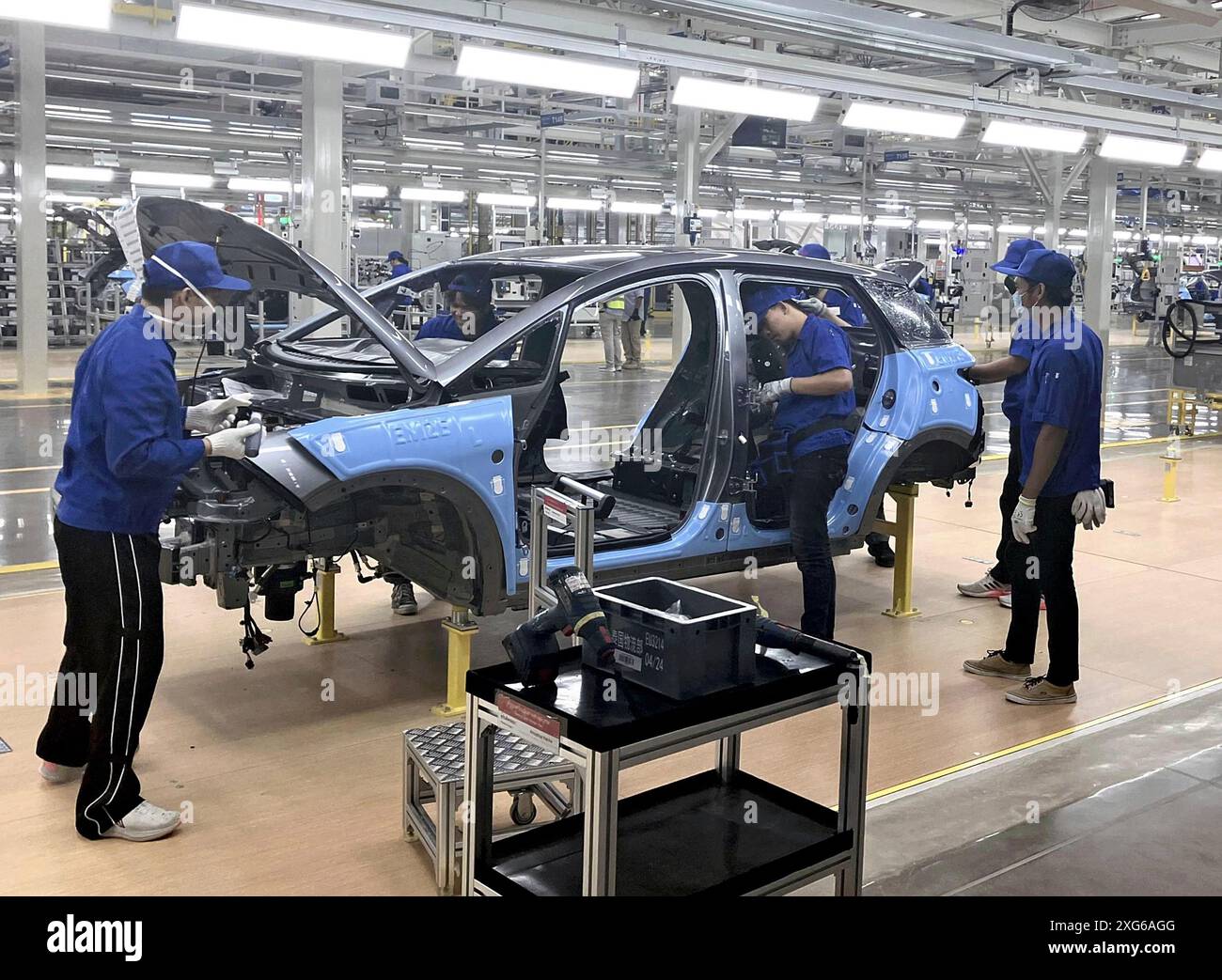 Workers manufacture an electric vehicle at the new BYD factory in ...