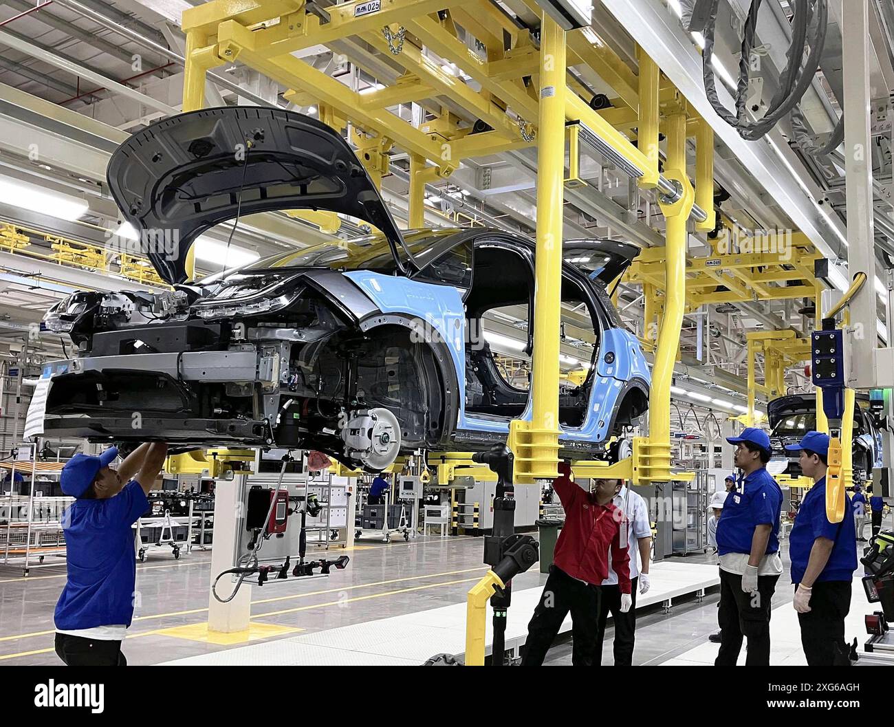 Workers manufacture an electric vehicle at the new BYD factory in ...