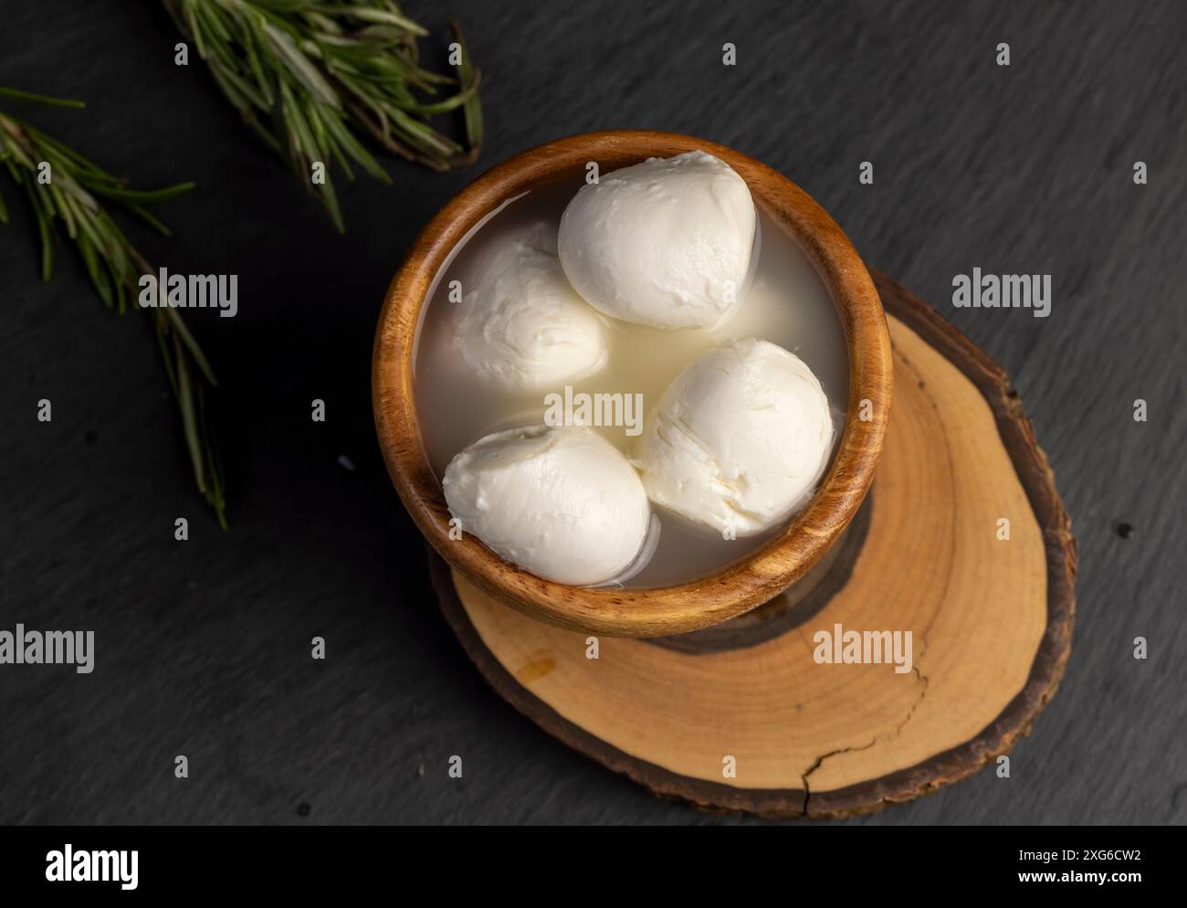 white cheese balls in a wooden bowl, milk food soft cheese in brine ...