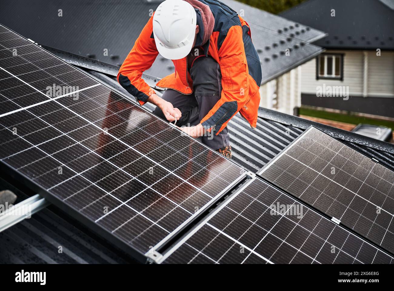 Man installer mounting photovoltaic solar panels on roof of house ...