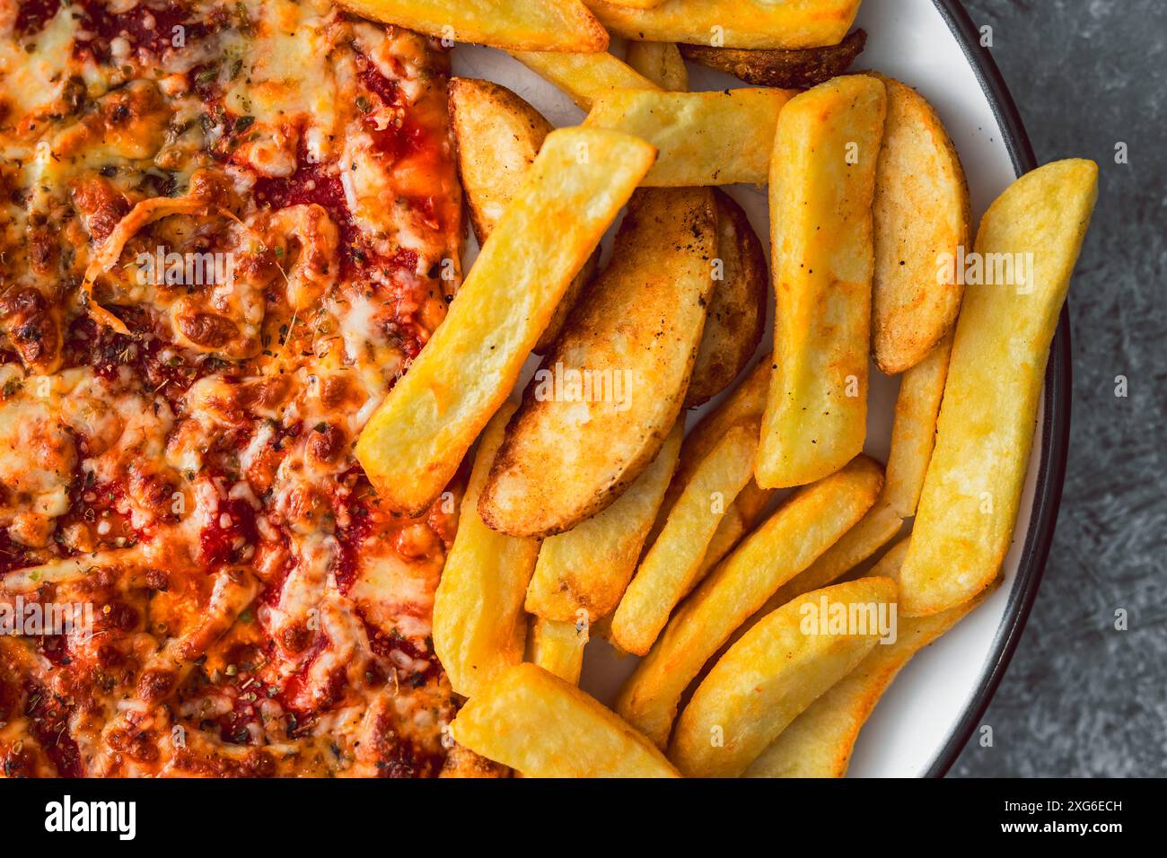 plate with half pizza half chips, concept of fast food or unhealthy ...
