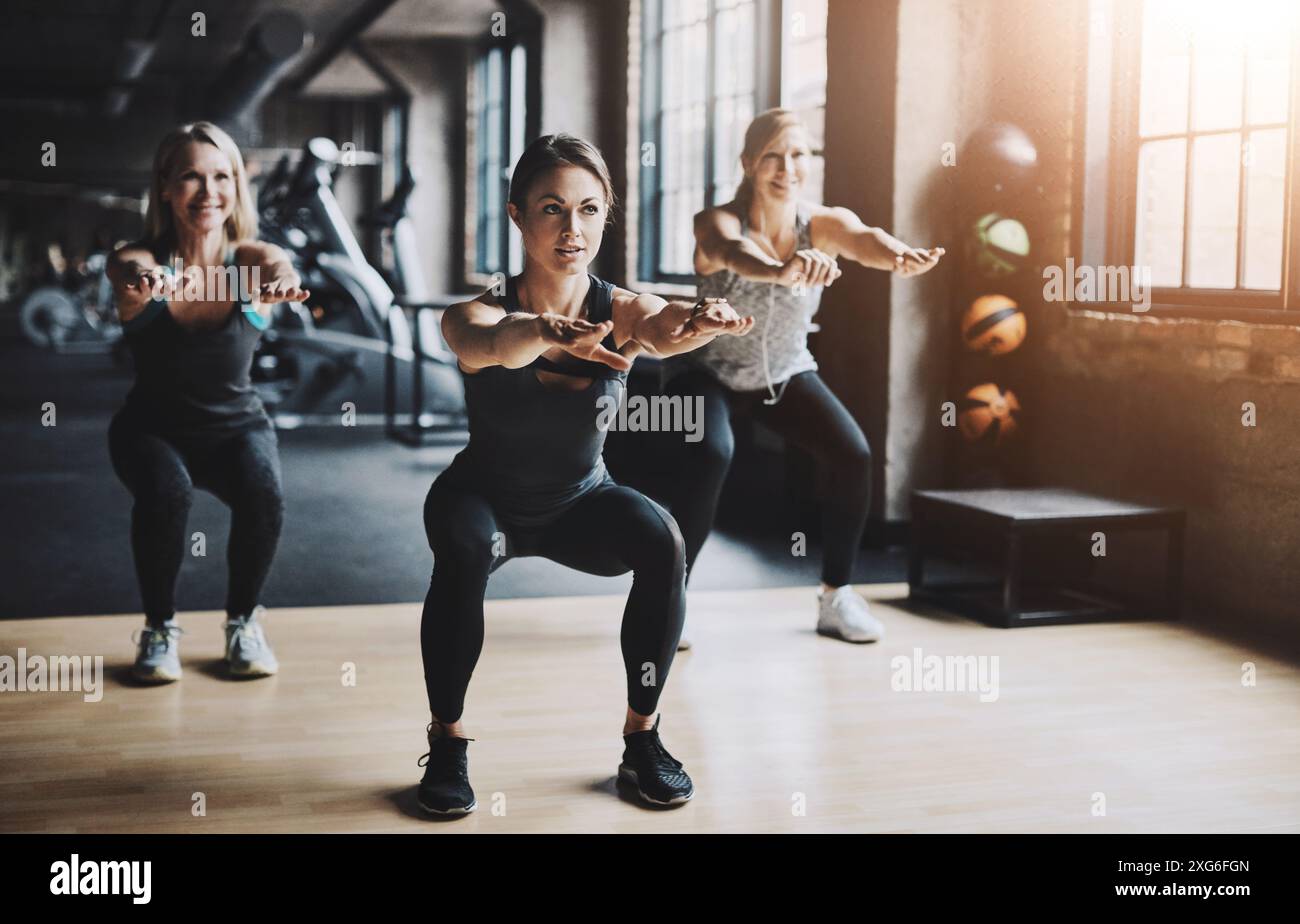 Exercise, class and people with squat in gym for muscle development ...